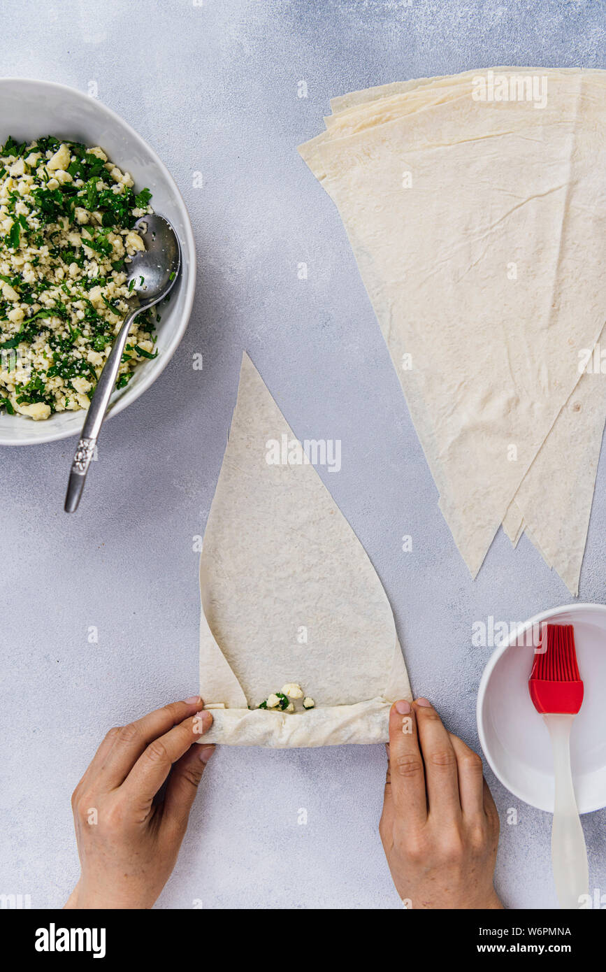 Woman making Turkish borek with phyllo sheets and cheese filling Stock ...