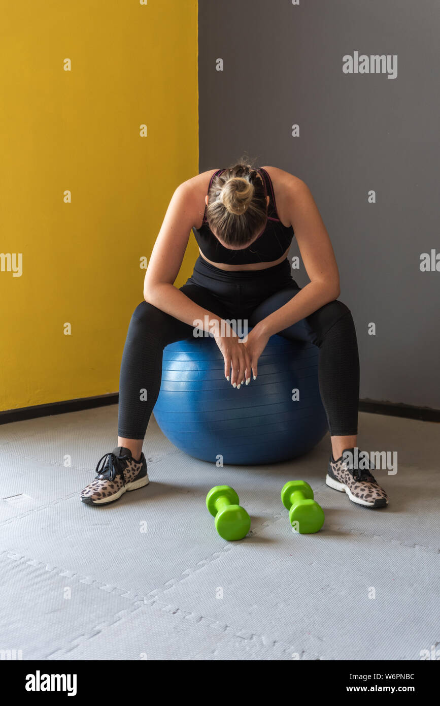 Sport woman sitting and resting after workout or exercise in fitness ...