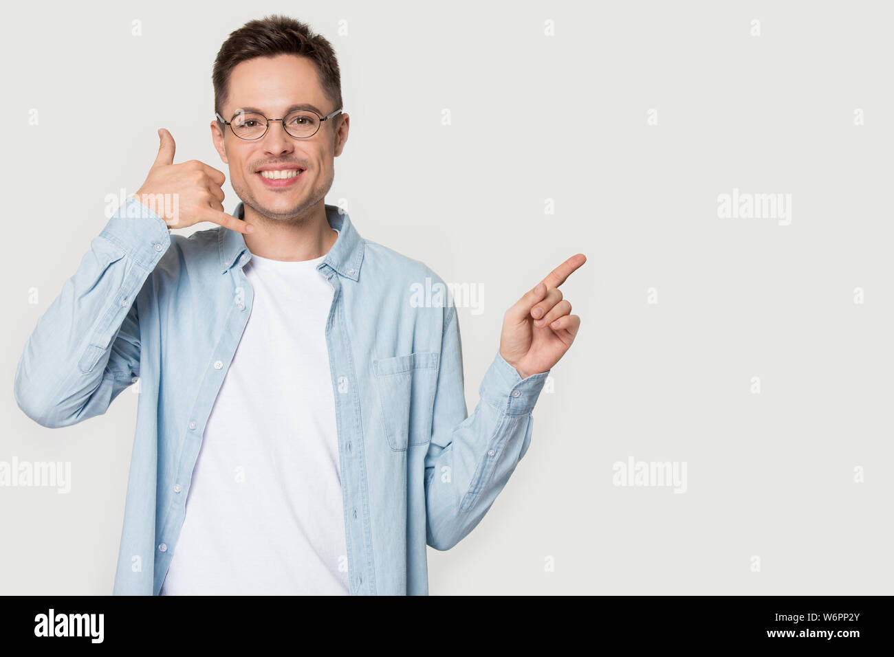 Man makes call me gesture pointing finger aside at announcement Stock ...