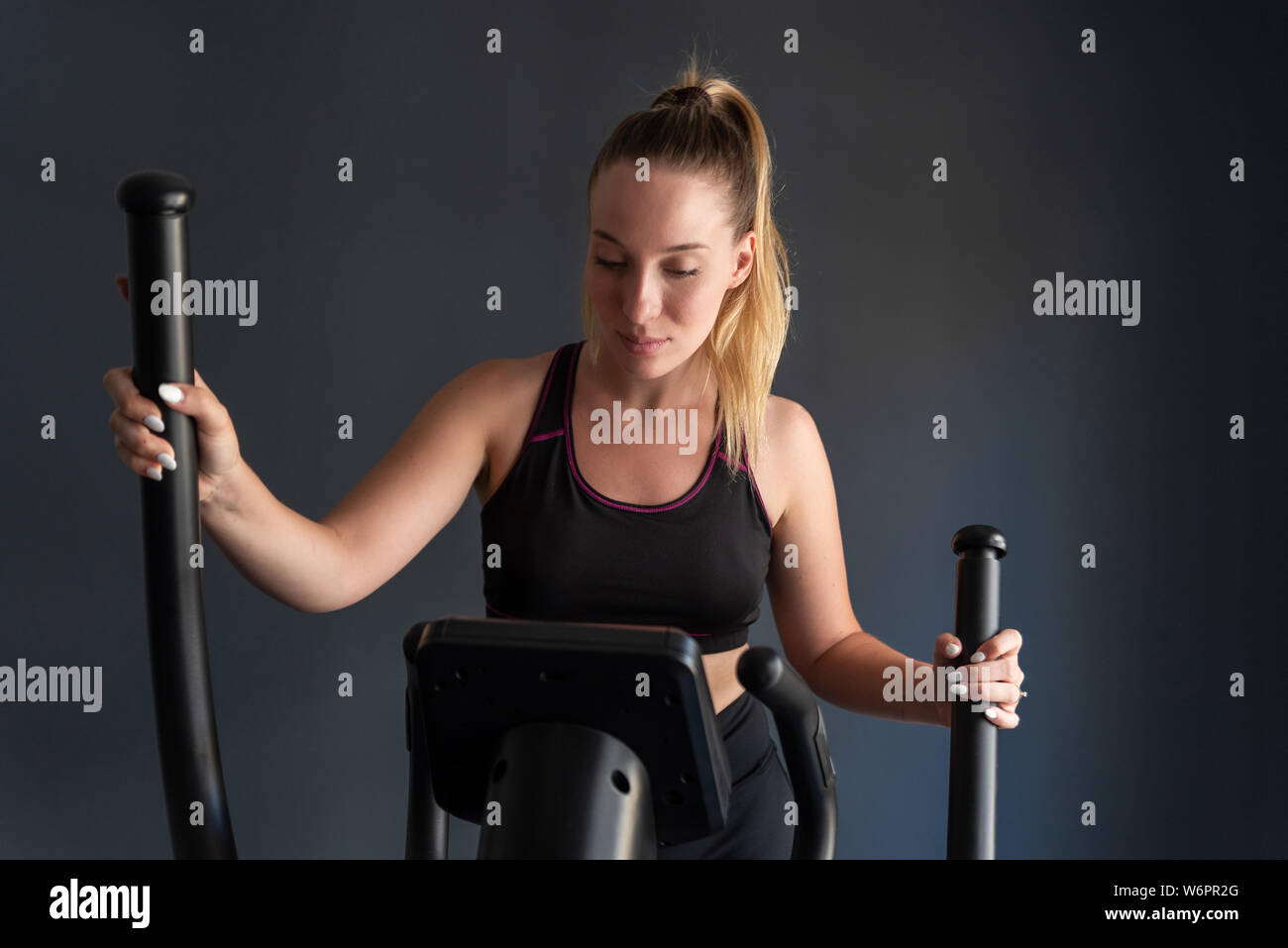 Woman Exercise Elliptical cardio running workout at fitness gym Stock ...