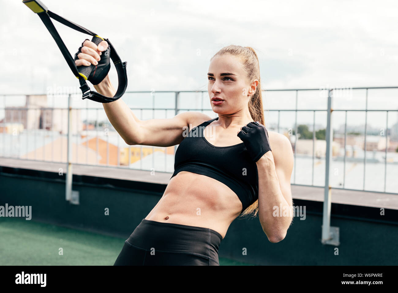 Fitness woman using suspension strap for exercises. Athlete working out ...