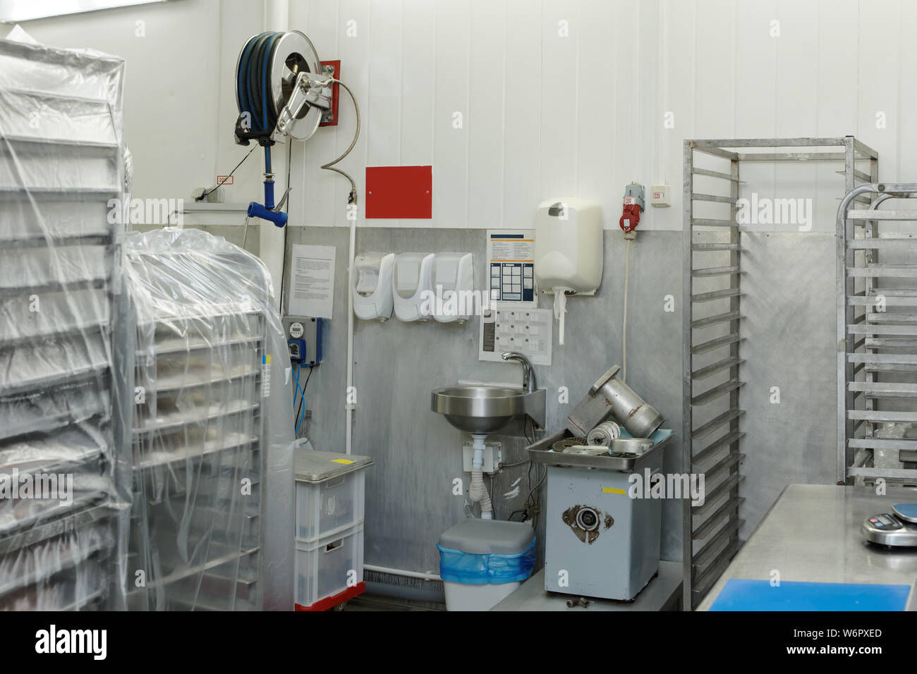 Food processing plant storage room with rack trolleys and hand washing ...