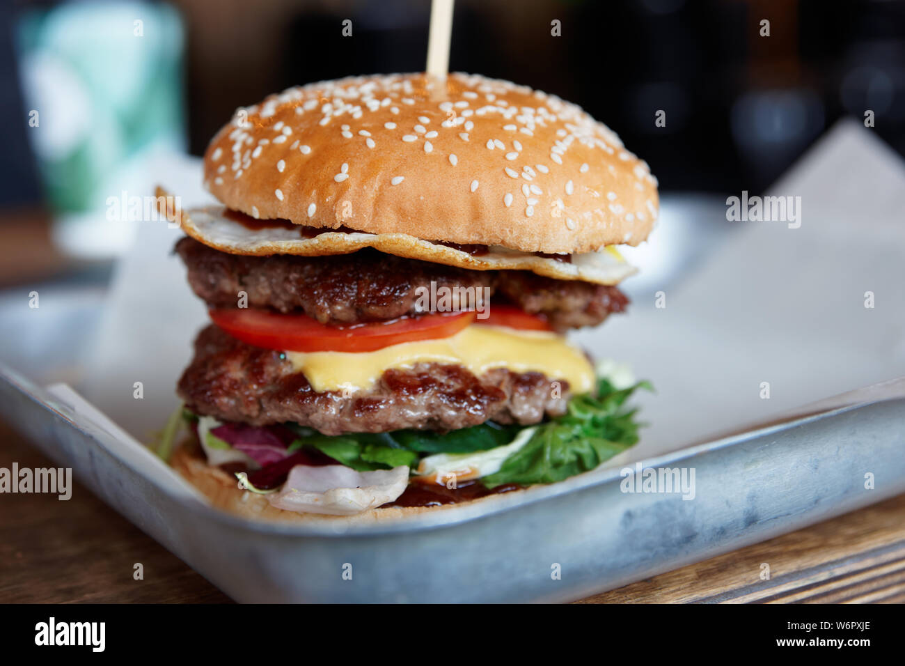Big burger on restaurant table, close-up, focus on the bun Stock Photo ...
