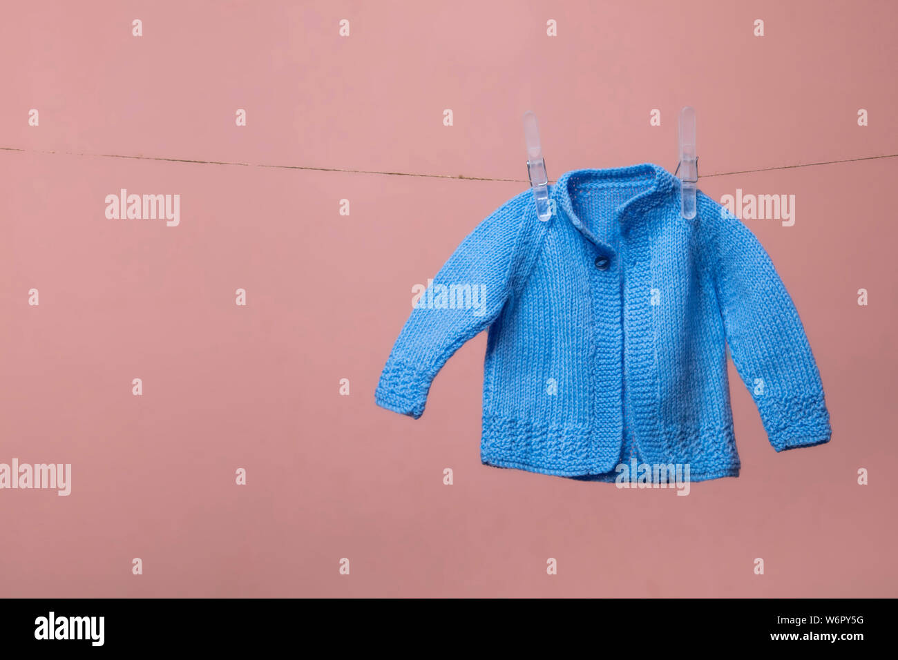 cute knitted new born baby jumper hanging on a clothes line against ...