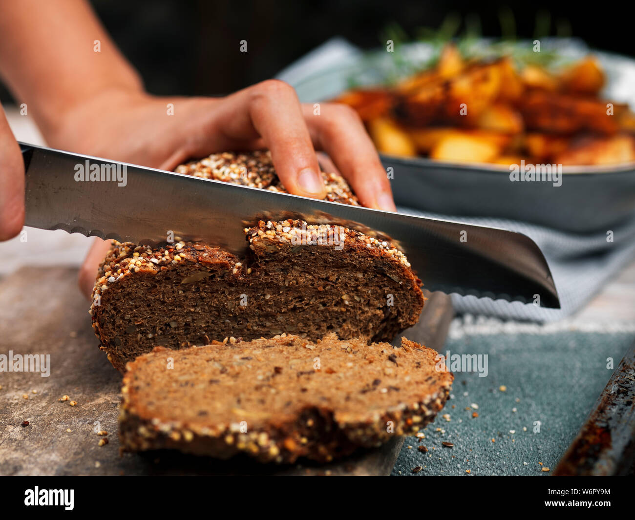 Hand cutting bread Stock Photo - Alamy