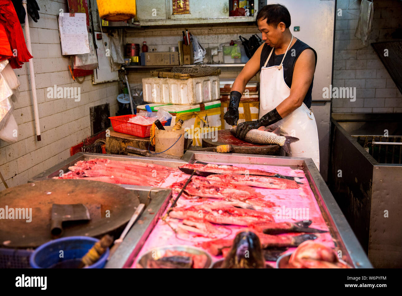 Fishmonger cutting a fish at Sheung Wan market. Hong Kong Stock Photo ...