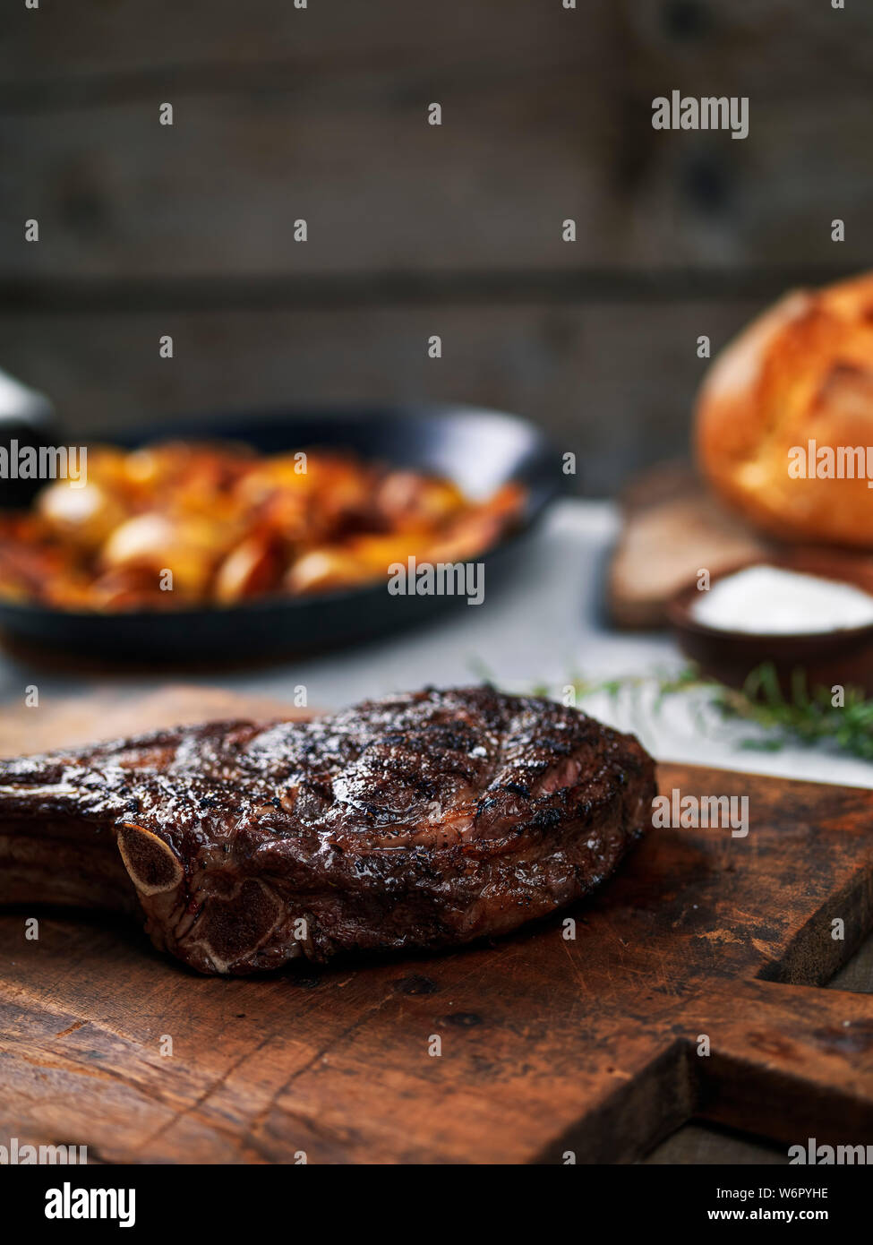 Grilled angus beef tomahawk steak on a cutting board with roasted ...