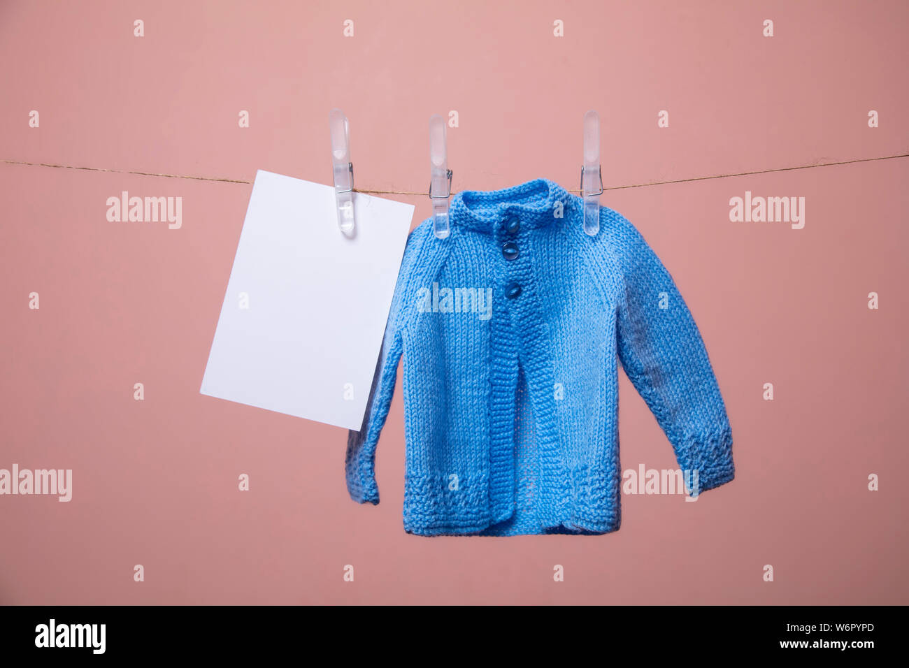 Knitted baby jumper and blank card hanging on a clothes line Stock ...