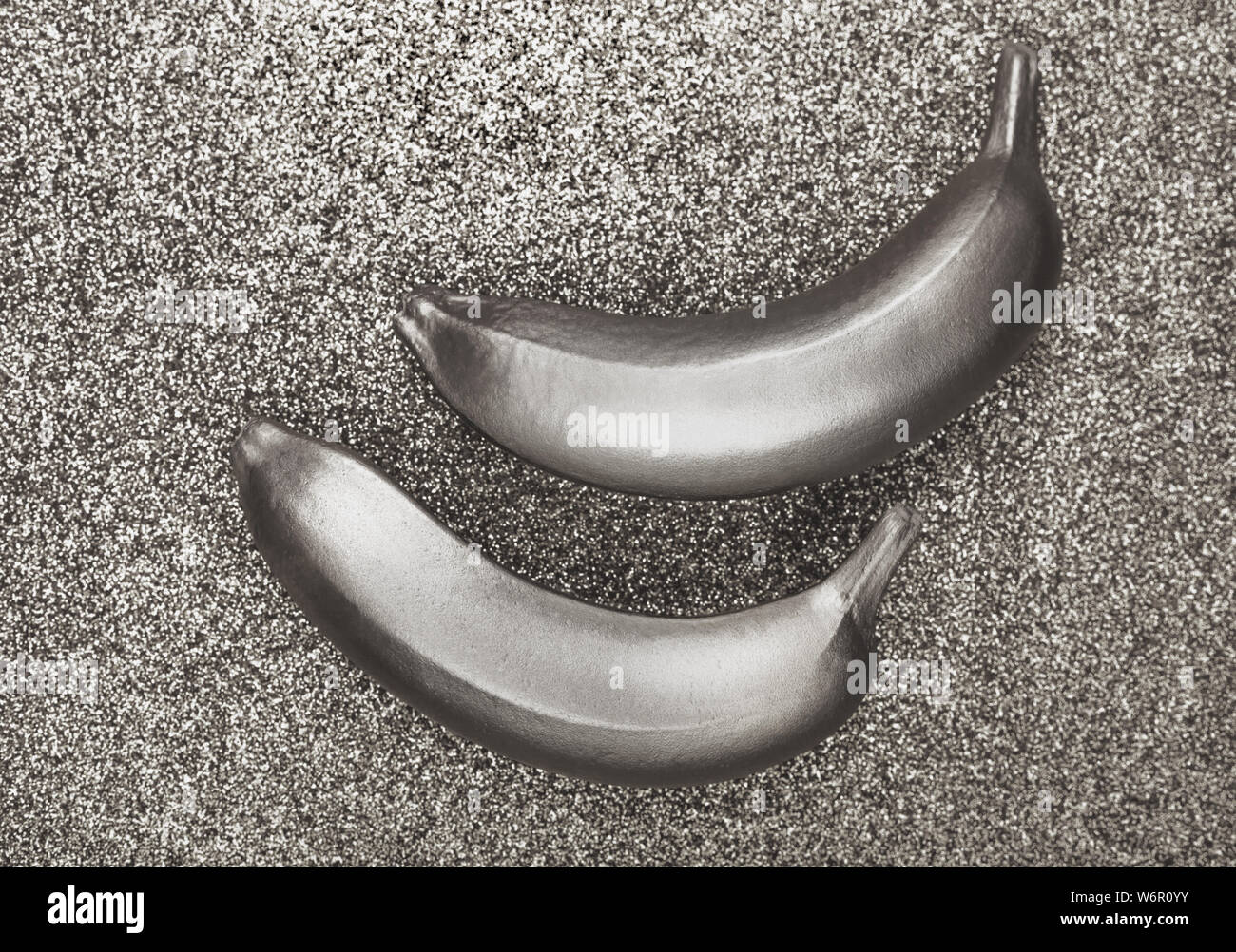 Silver colour metal food, metallic banana on glitter or shimmer ...