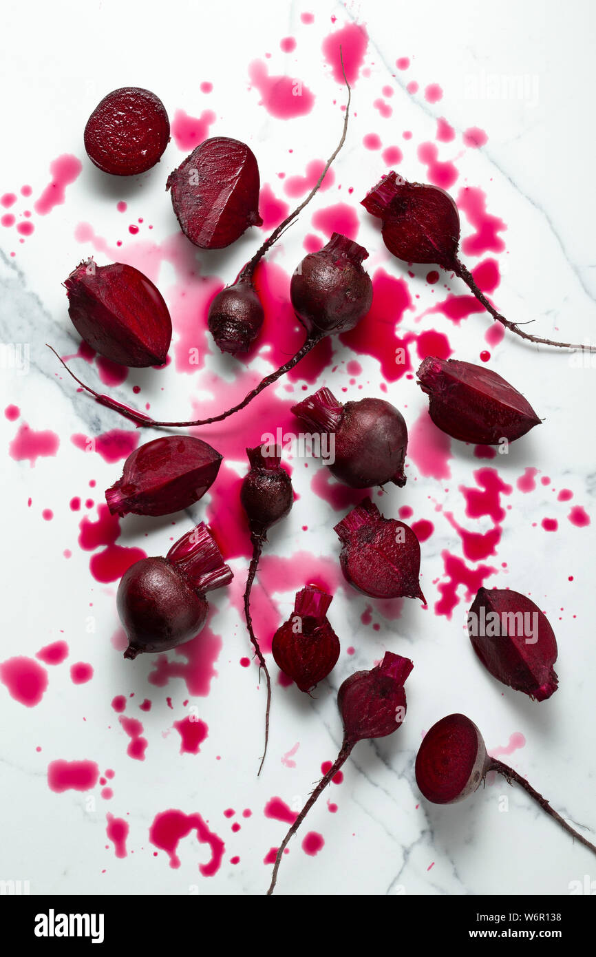 Washed and cut baby beetroots on a marble tile surface, with juice ...