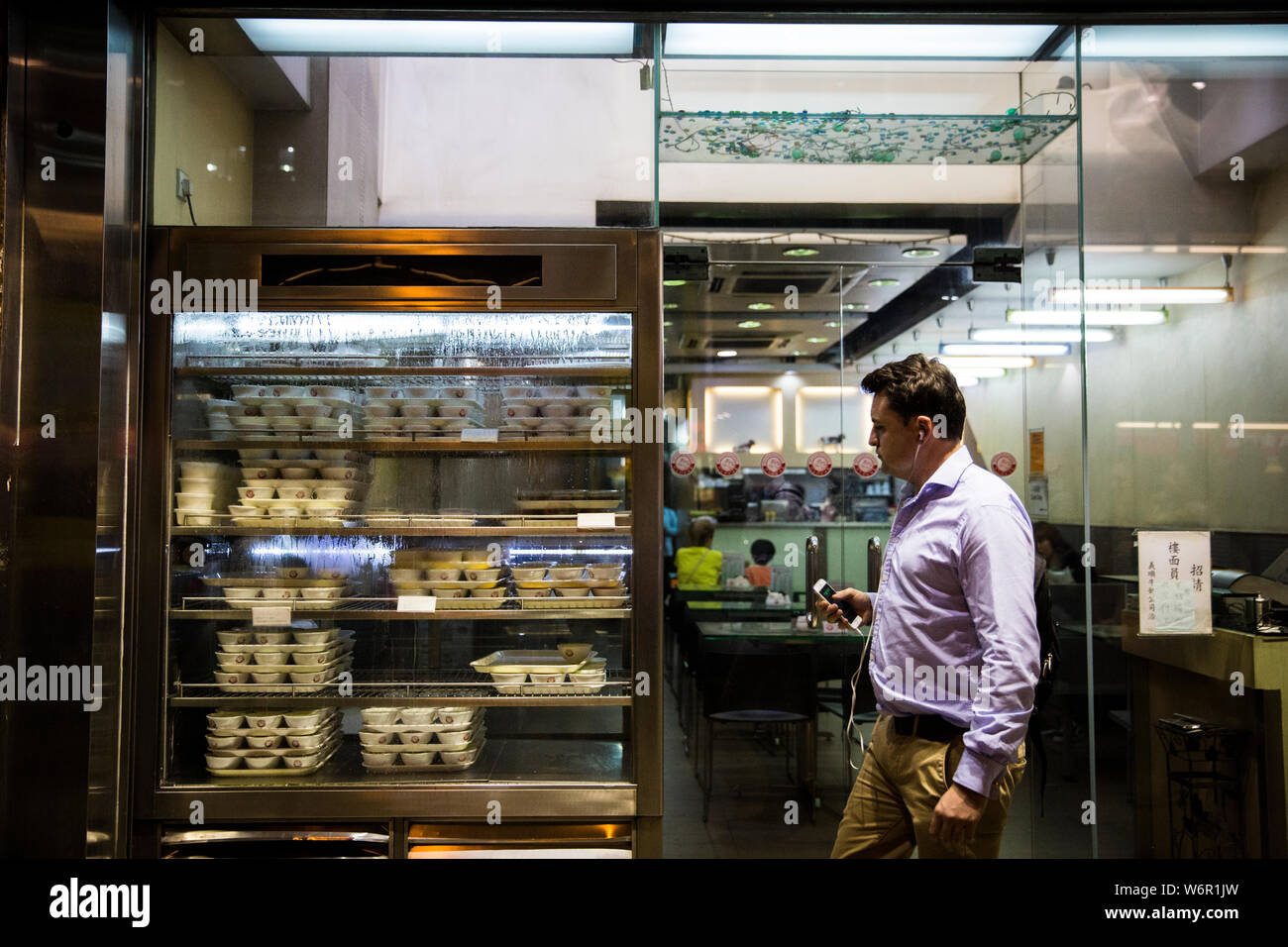 Man walking by a restaurant with a food display by the entrance. Hong ...