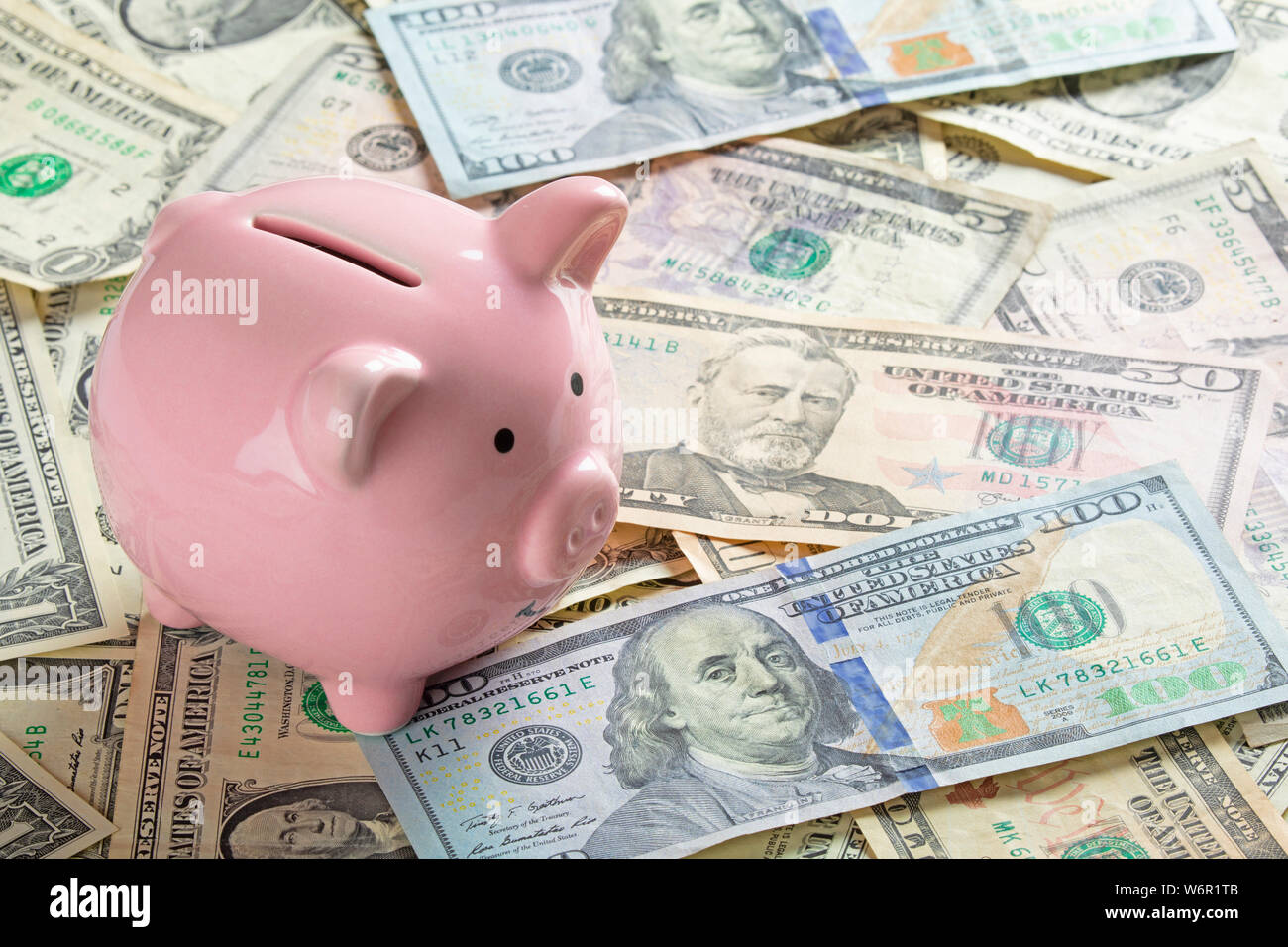 United States bank notes and coins with a calculator, pen, and piggy ...
