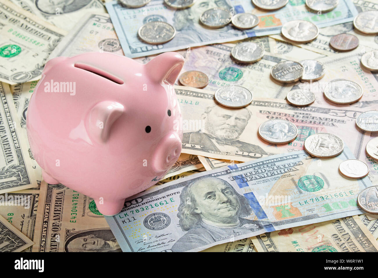 United States bank notes and coins with a piggy bank Stock Photo - Alamy