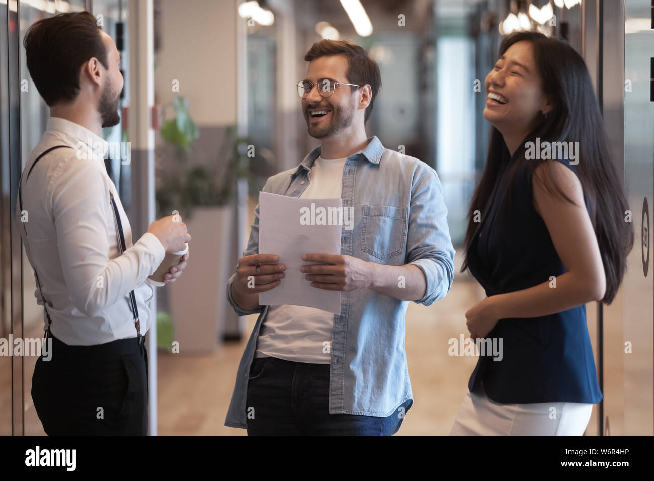 Friendly happy three diverse colleagues talking laughing at work break ...