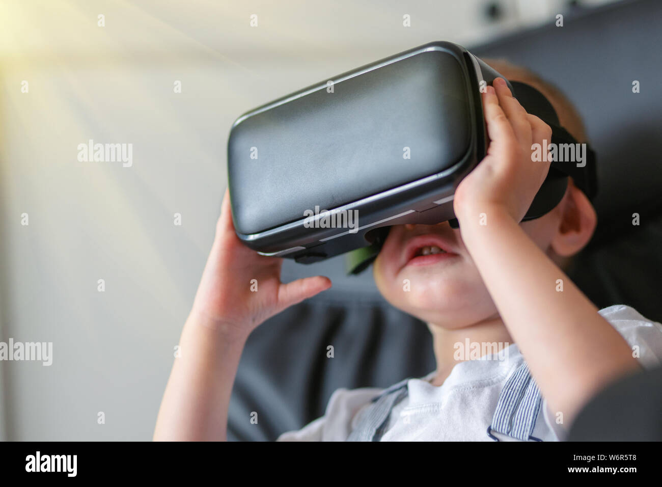 Child using new Virtual Reality, VR cardboard glasses. happy little boy ...