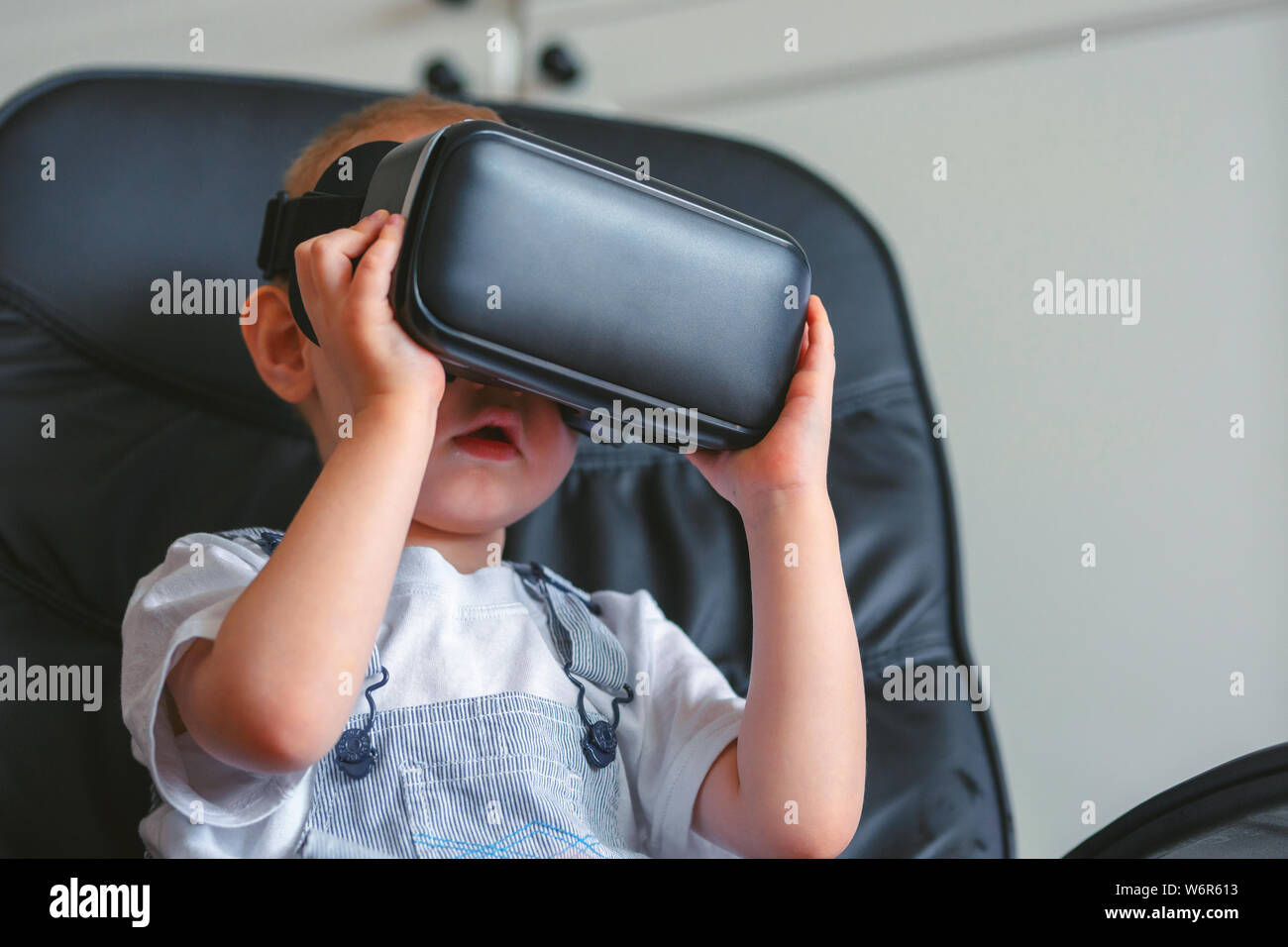 Child using new Virtual Reality, VR cardboard glasses. happy little boy ...