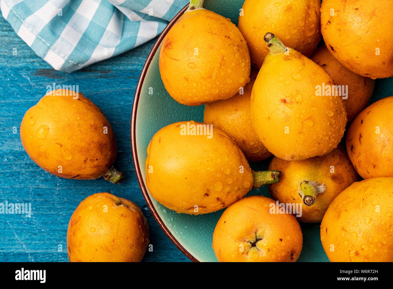 Fresh loquats (medlars) in blue turquoise bowl. Rustic and healthy ...
