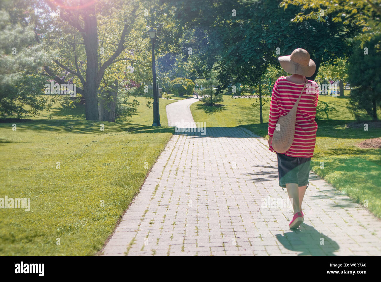 Lady walking thru the park, seen from behind Stock Photo - Alamy