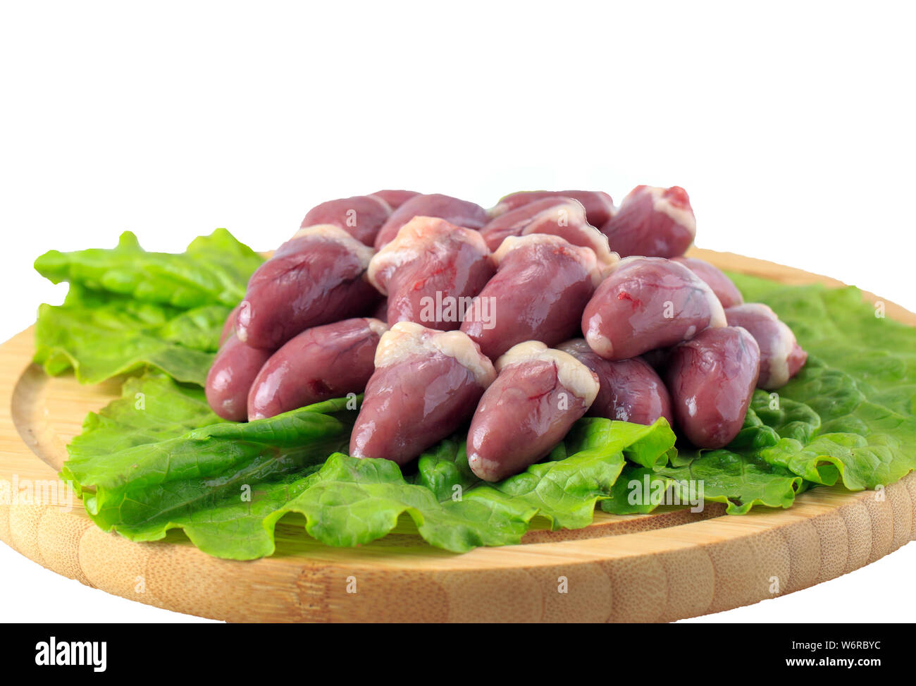 raw chicken hearts on a wooden board on white background Stock Photo ...