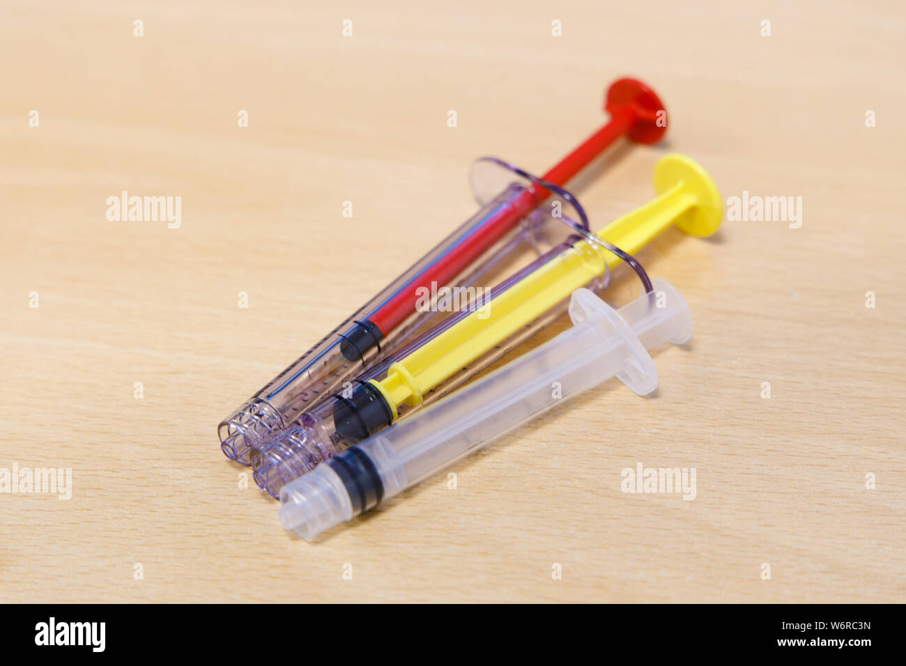 Three small medical syringes of different size and colors Stock Photo ...