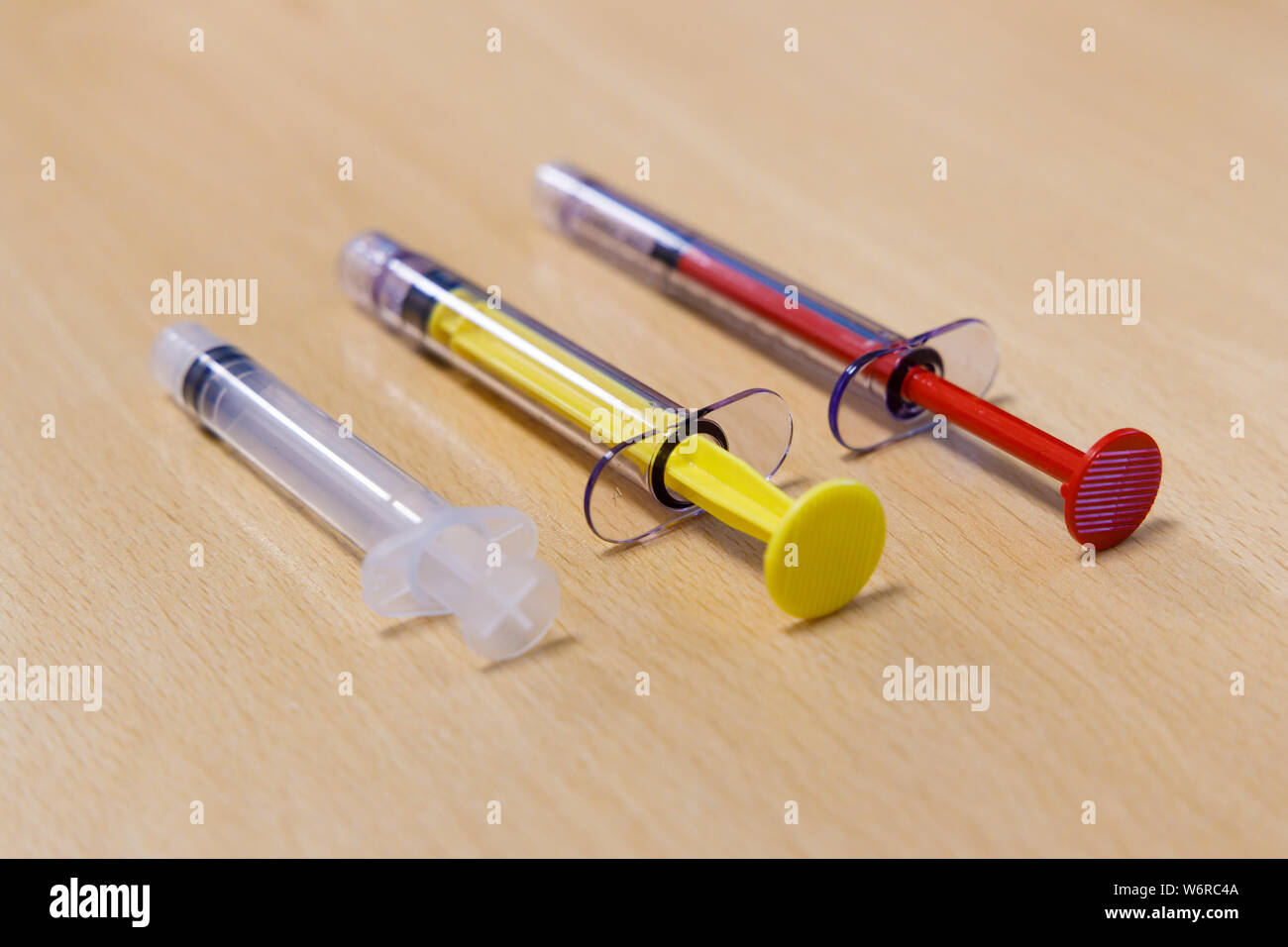 Three small medical syringes of different size and colors Stock Photo ...