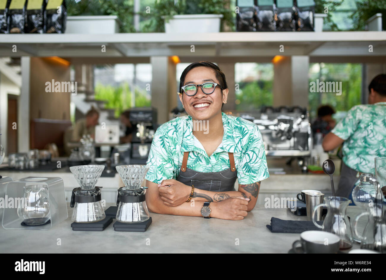 Lifestyle portrait of smiling balinese millennial barista wearing ...