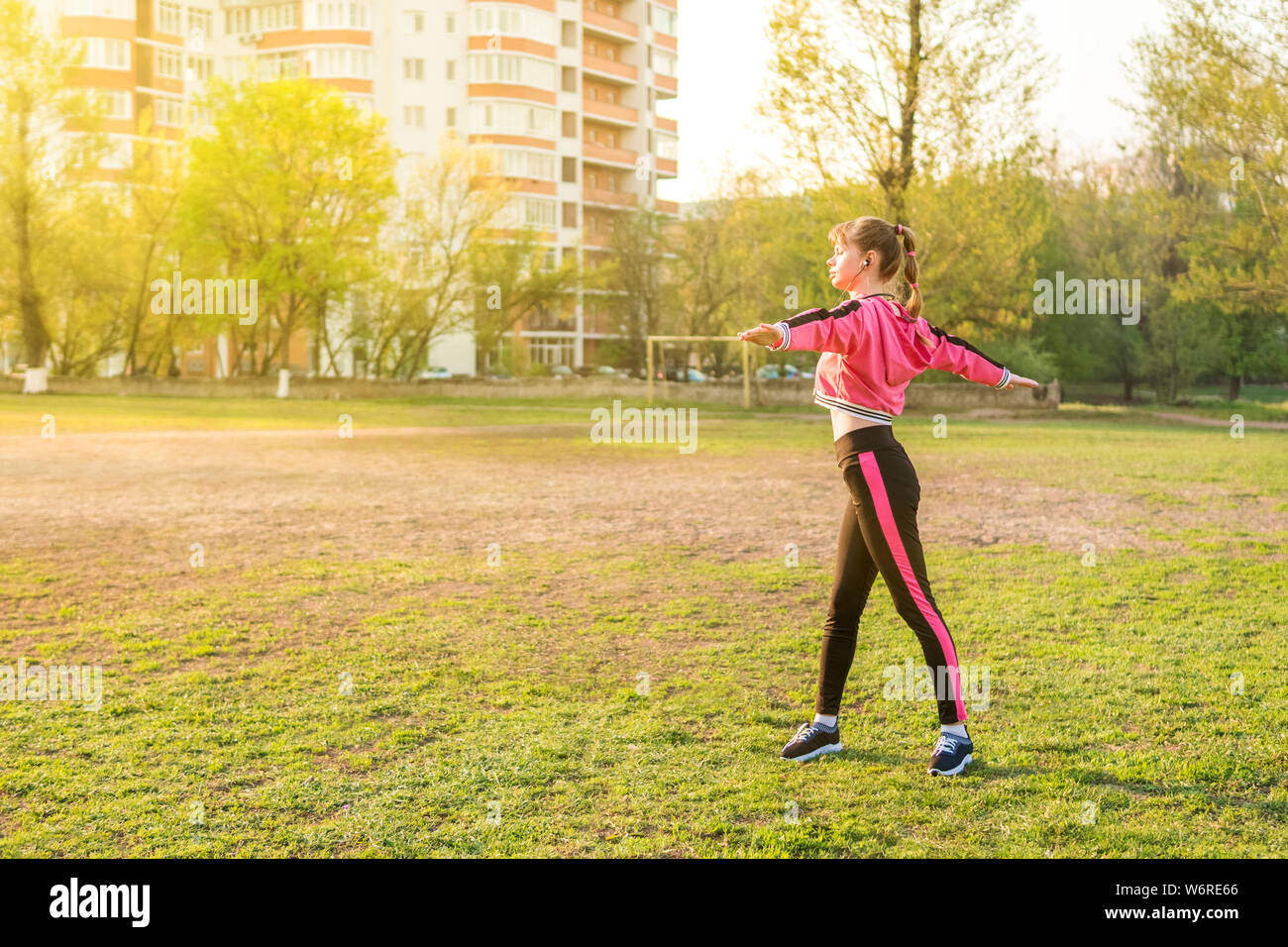beautiful athletic woman doing exercises with her arms spread to the ...