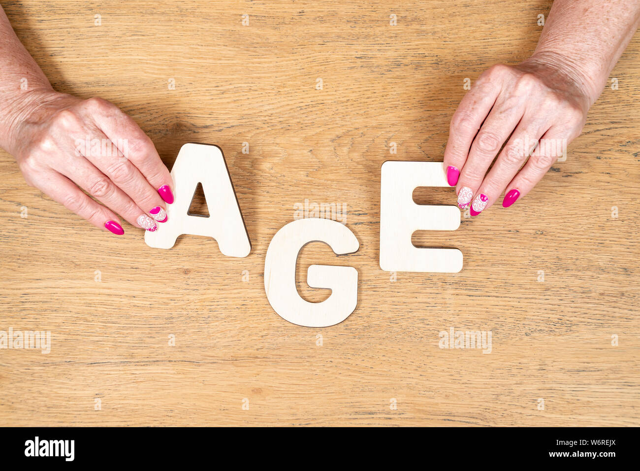 word age, spread out of wooden letters with old female hands Stock ...