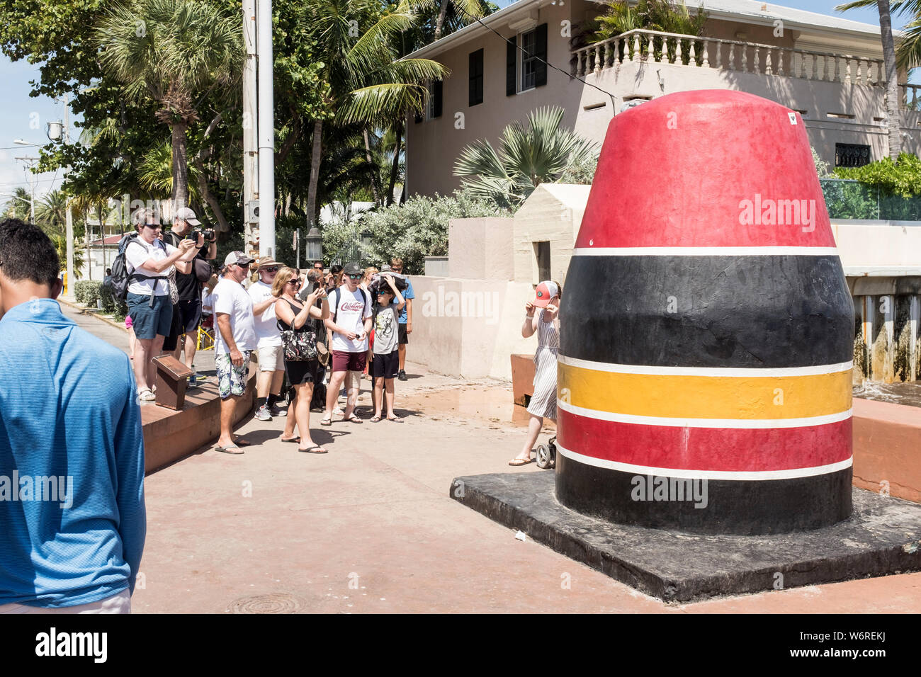 Tourists gather around waiting to take photos of the monument marking ...
