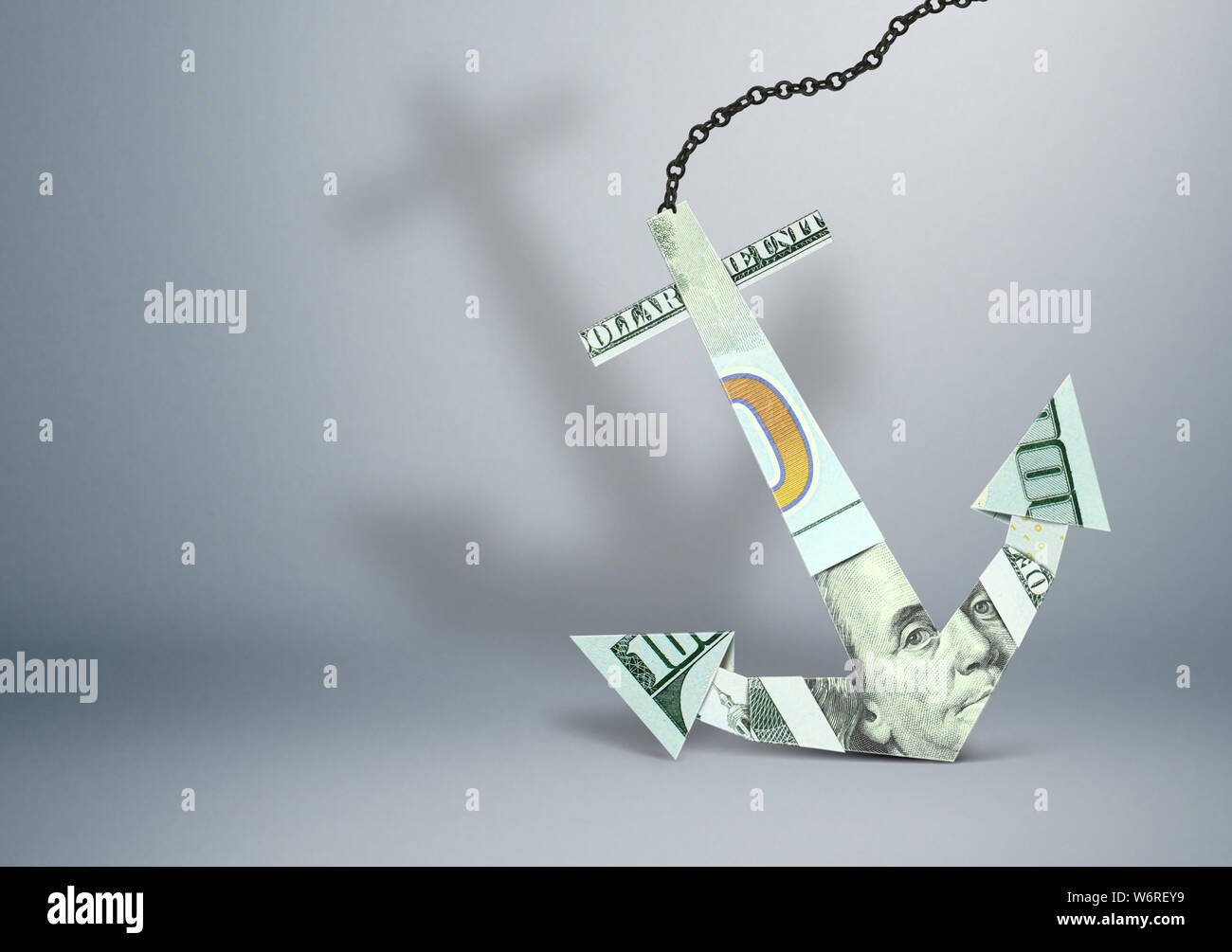 financial burden concept, anchor made of money Stock Photo - Alamy