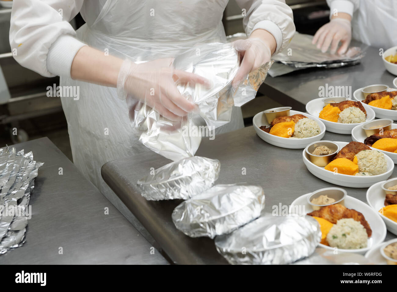 Chef is wrapping airline food in foil, professional kitchen Stock Photo ...
