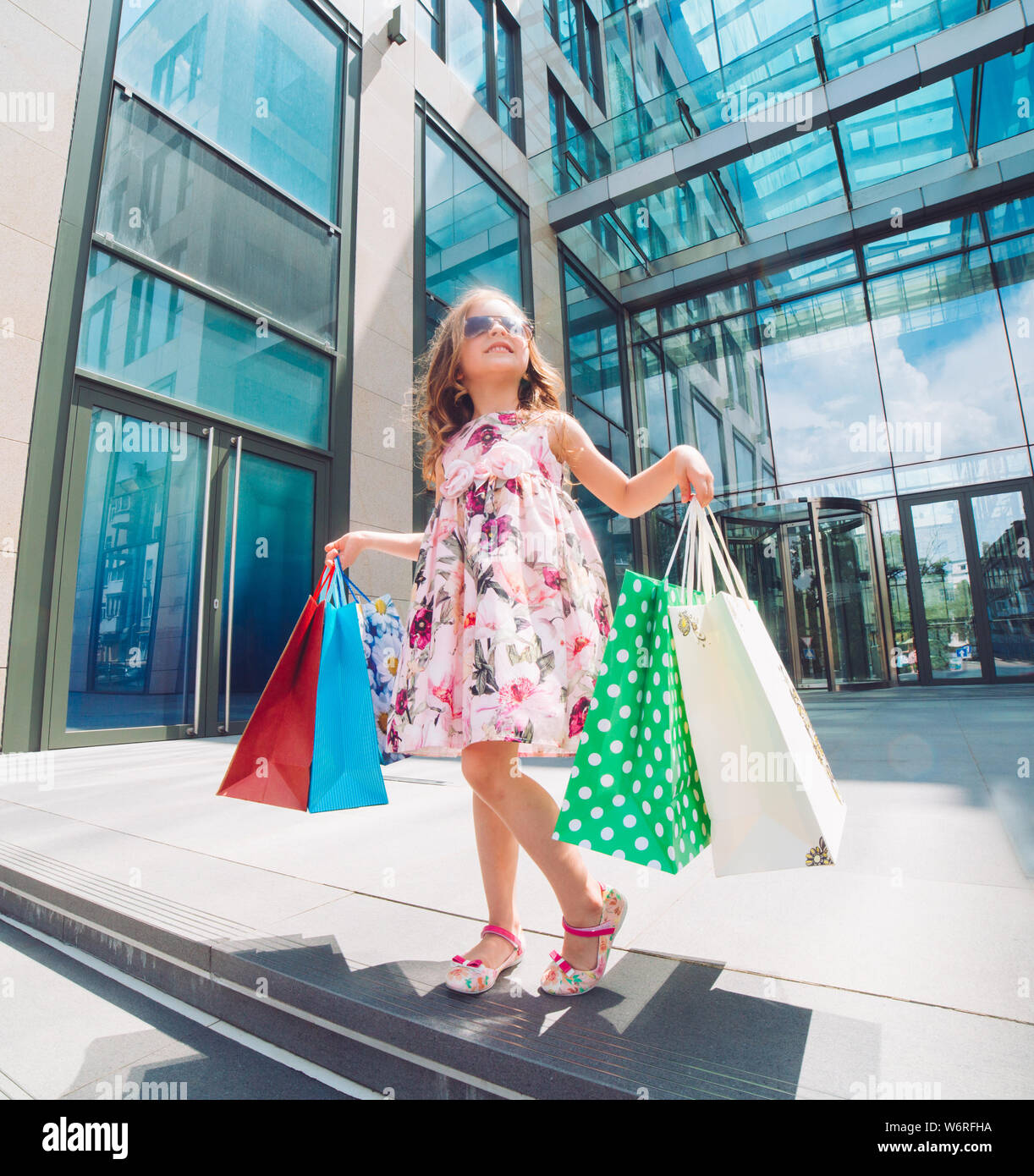 Cute little girl on shopping. Portrait of a kid with shopping bags ...
