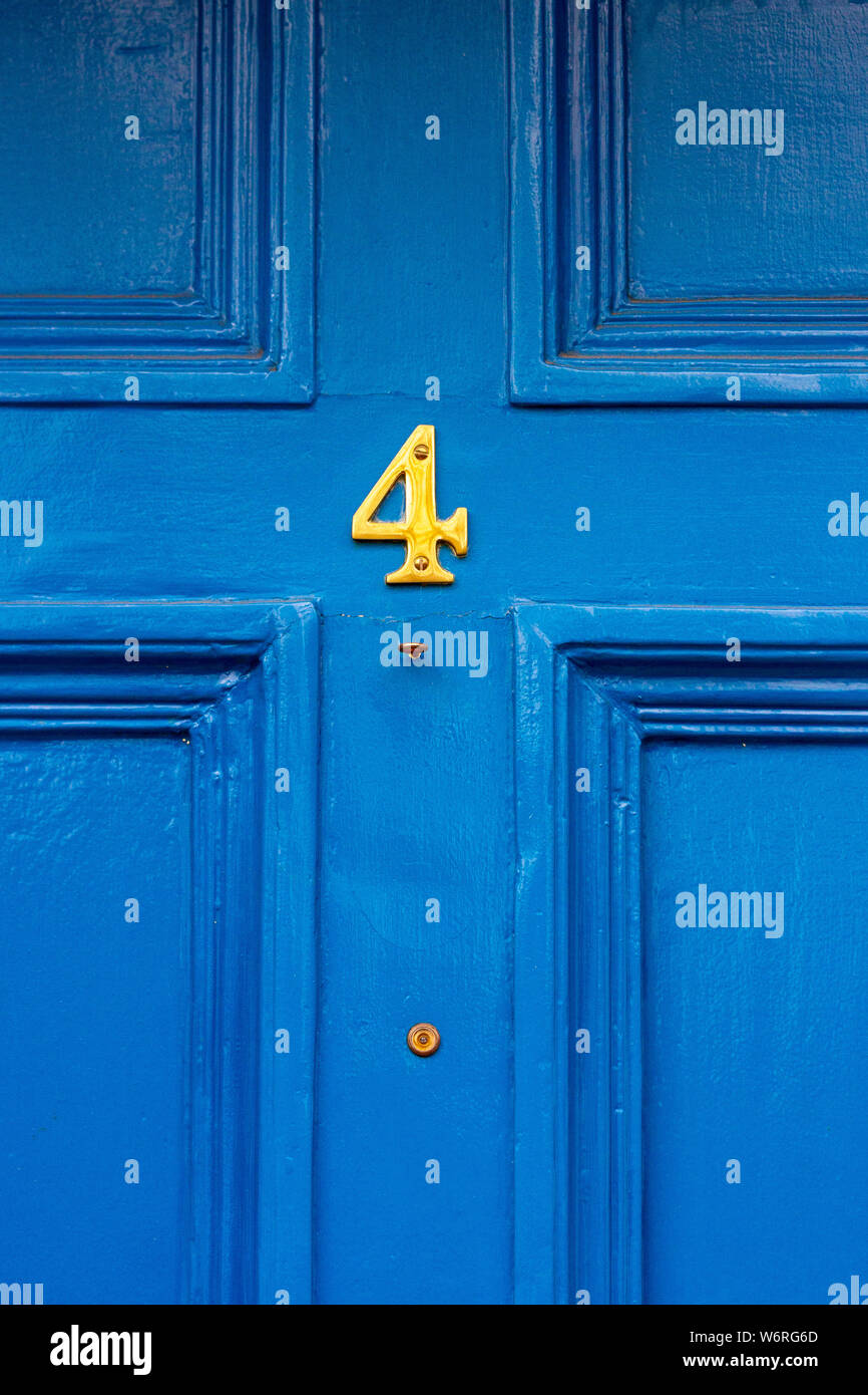House number 4 with the four as a yellow metal digit on a bright blue ...