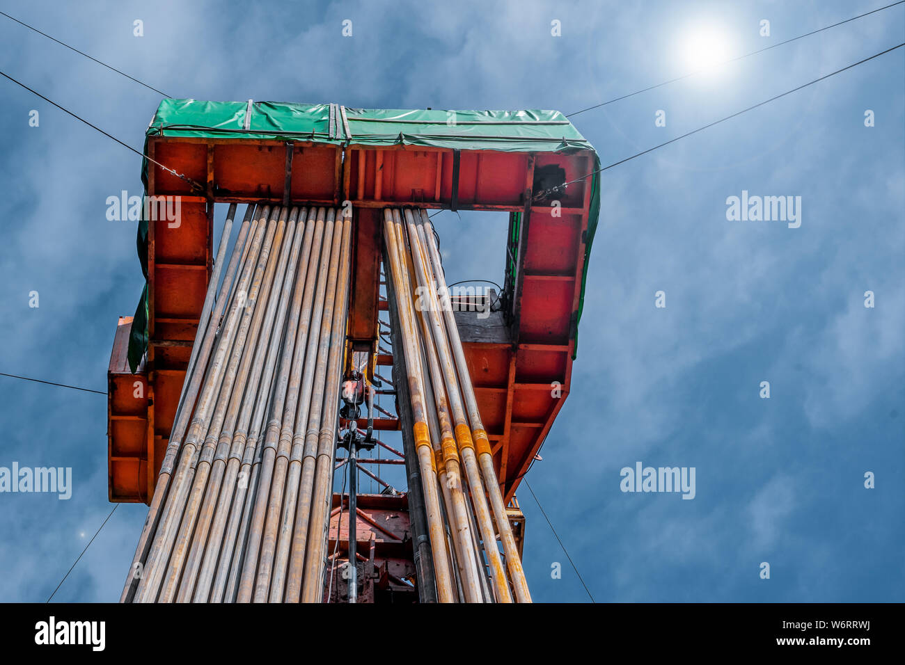 Oil rig derrick in oilfield against the bright blue sky. Drilling rig ...