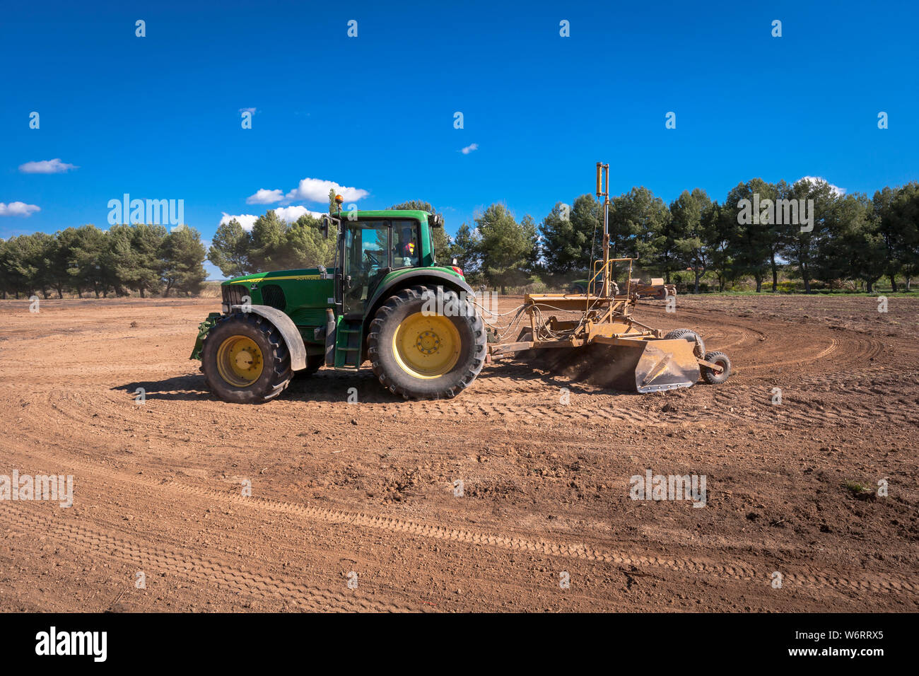 Tractors leveling in the field Stock Photo - Alamy