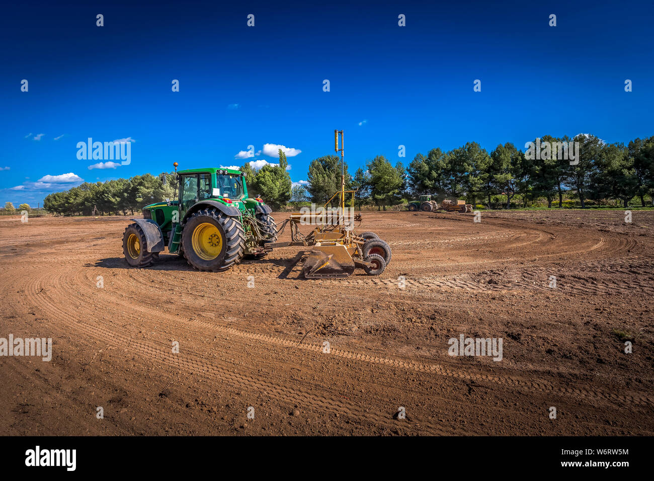 Tractors leveling in the field Stock Photo - Alamy