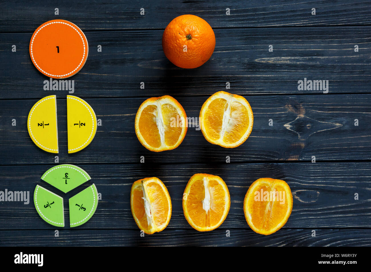 Сolorful math fractions and oranges as a sample on dark wooden ...
