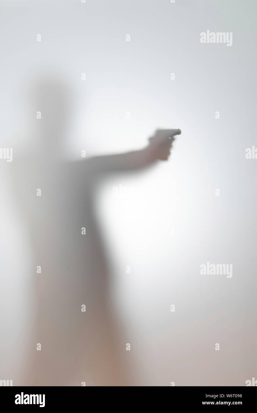 Blurred silhouette of a man with a gun Stock Photo - Alamy