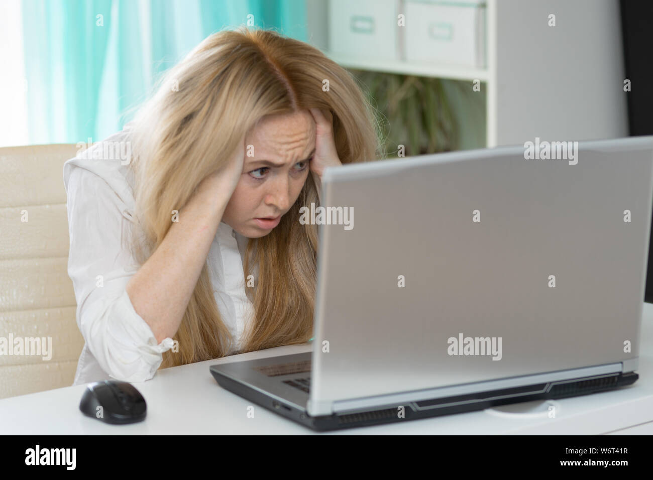 Portrait young shocked business woman sitting in front of laptop ...