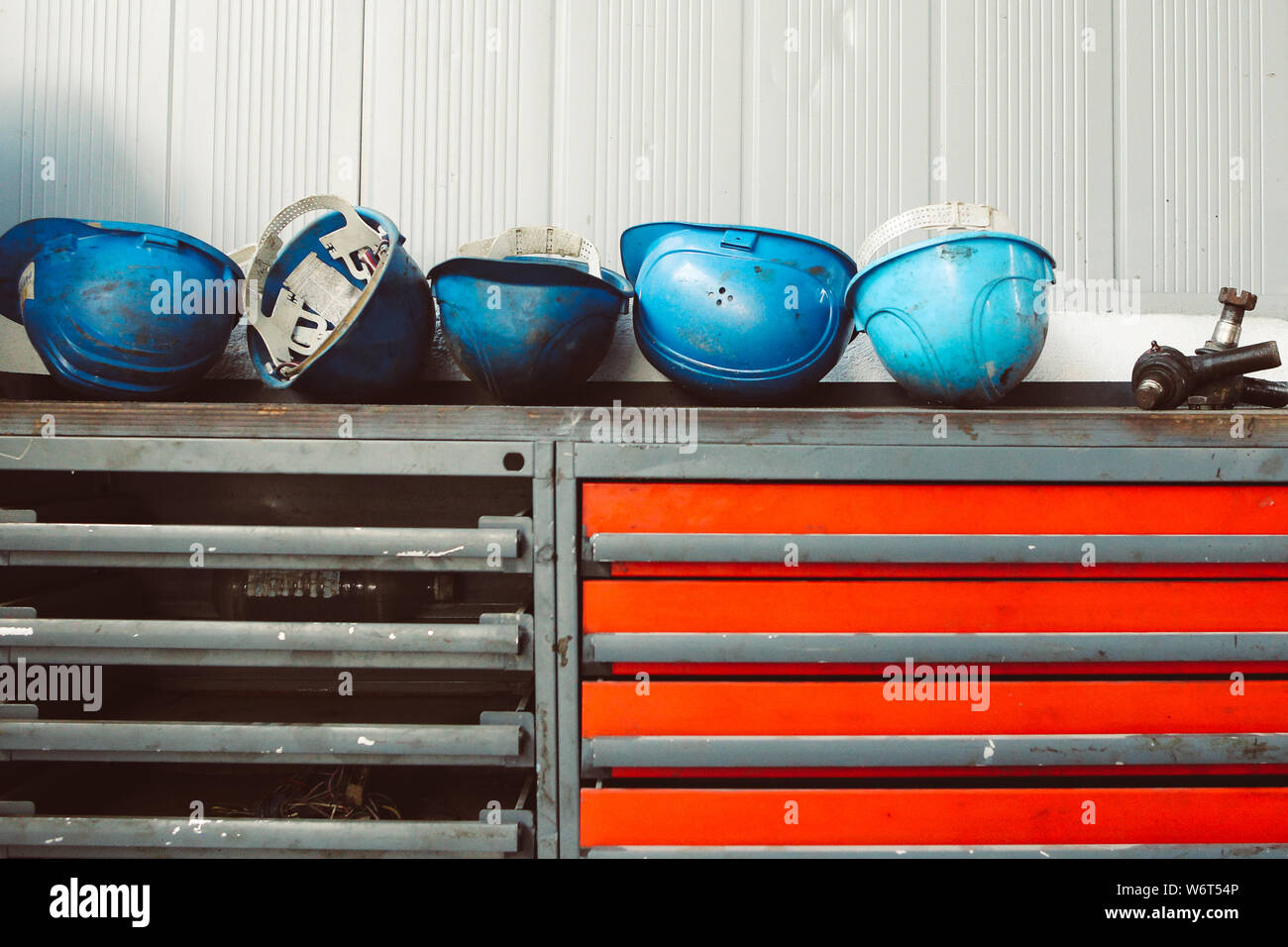 Dirty blue worker helmets on top of an old, rusty and dirty workbench ...