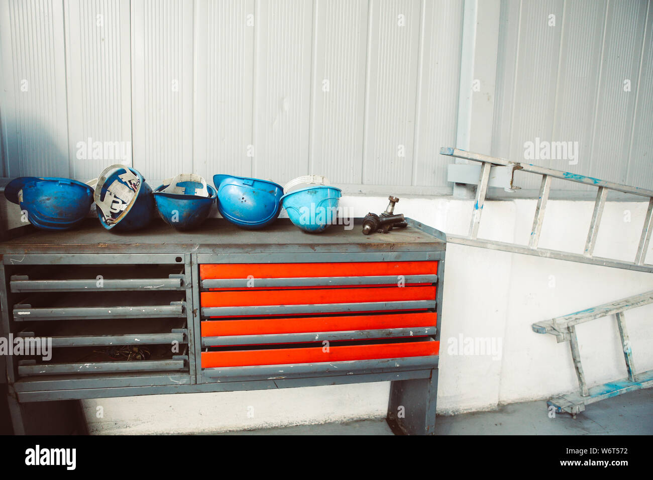 Dirty blue worker helmets on top of an old, rusty and dirty workbench ...