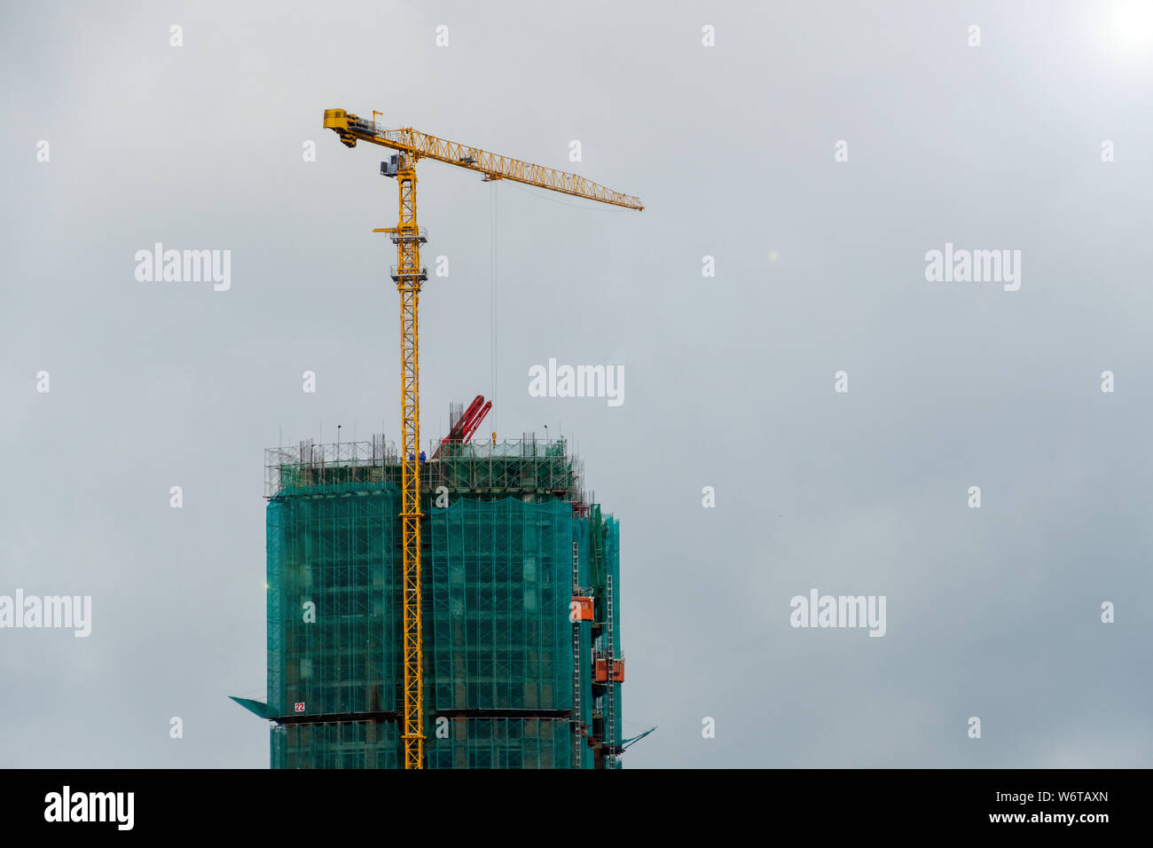 High-rise building, crane, blue sky, white clouds. Construction of ...