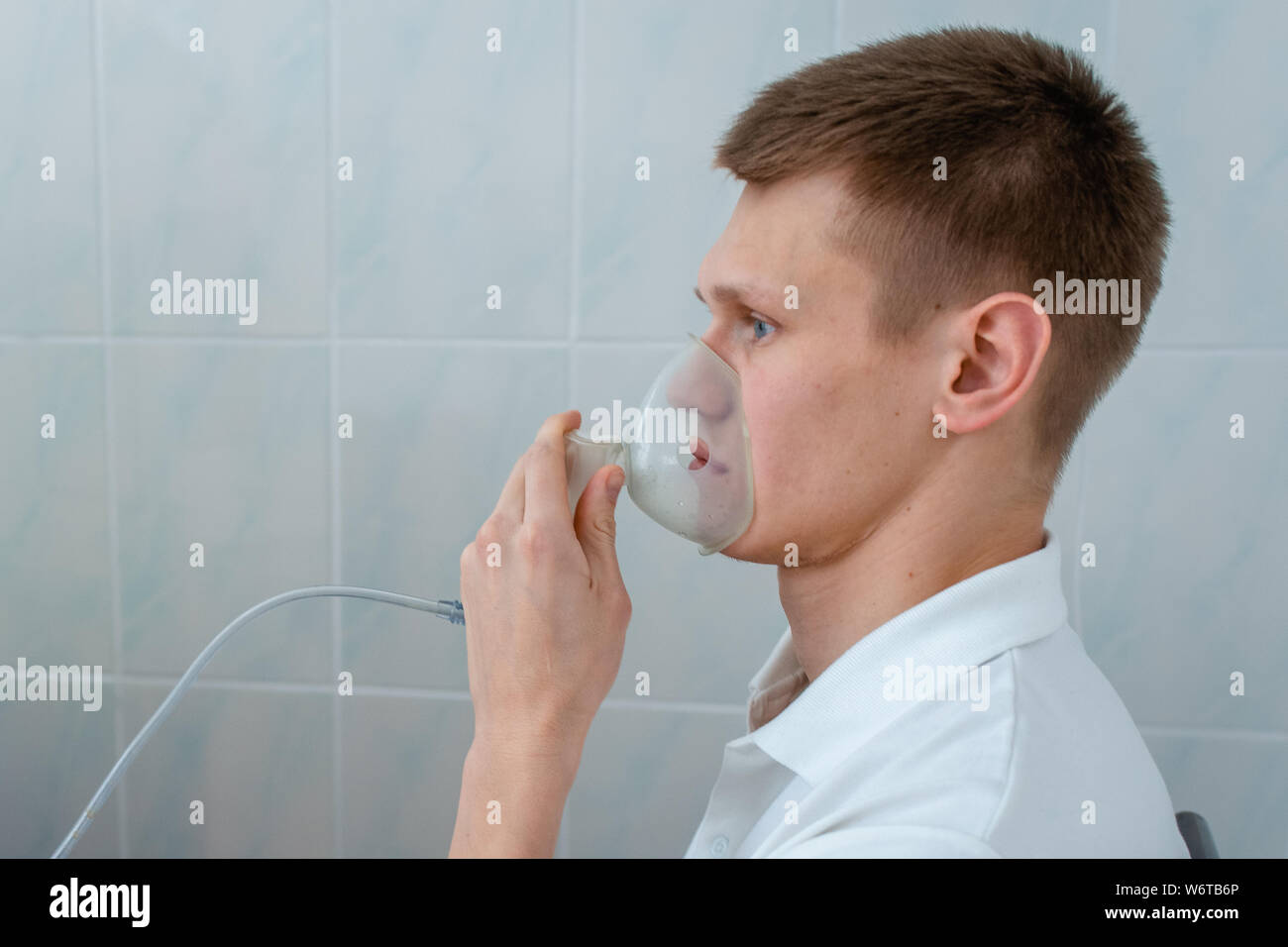 Young man wearing an inhalation mask. Use nebulizer and inhaler for the ...