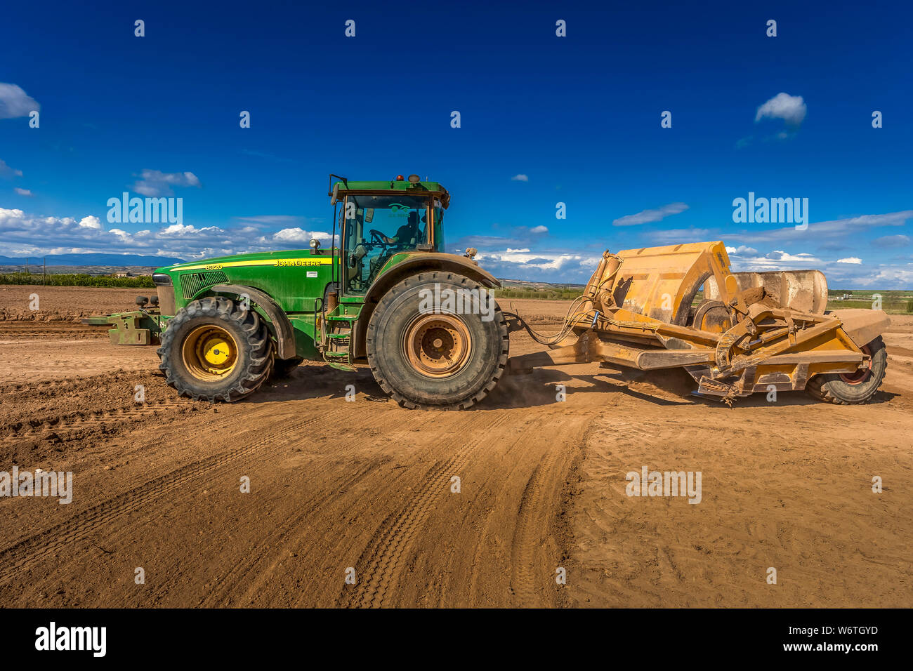 Tractors leveling in the field Stock Photo - Alamy