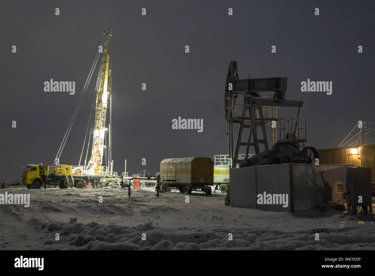 Oil rig and brightly lit industrial site at night. Blur photo effect ...