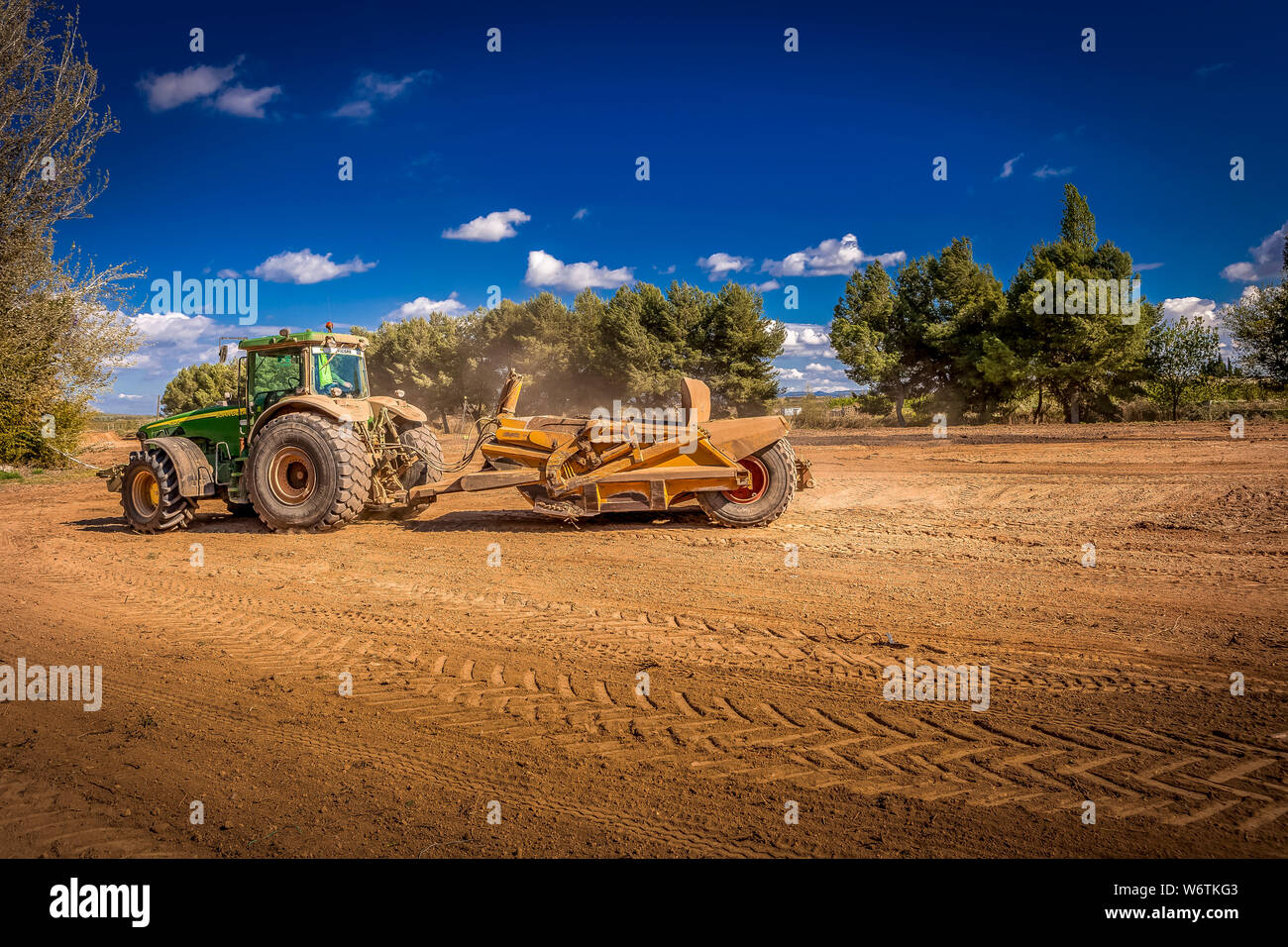 Tractors leveling in the field Stock Photo - Alamy