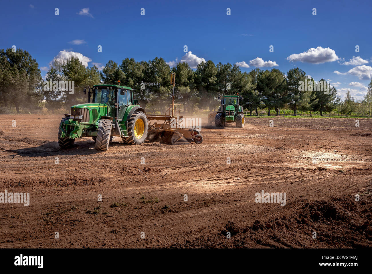 Tractors leveling in the field Stock Photo - Alamy