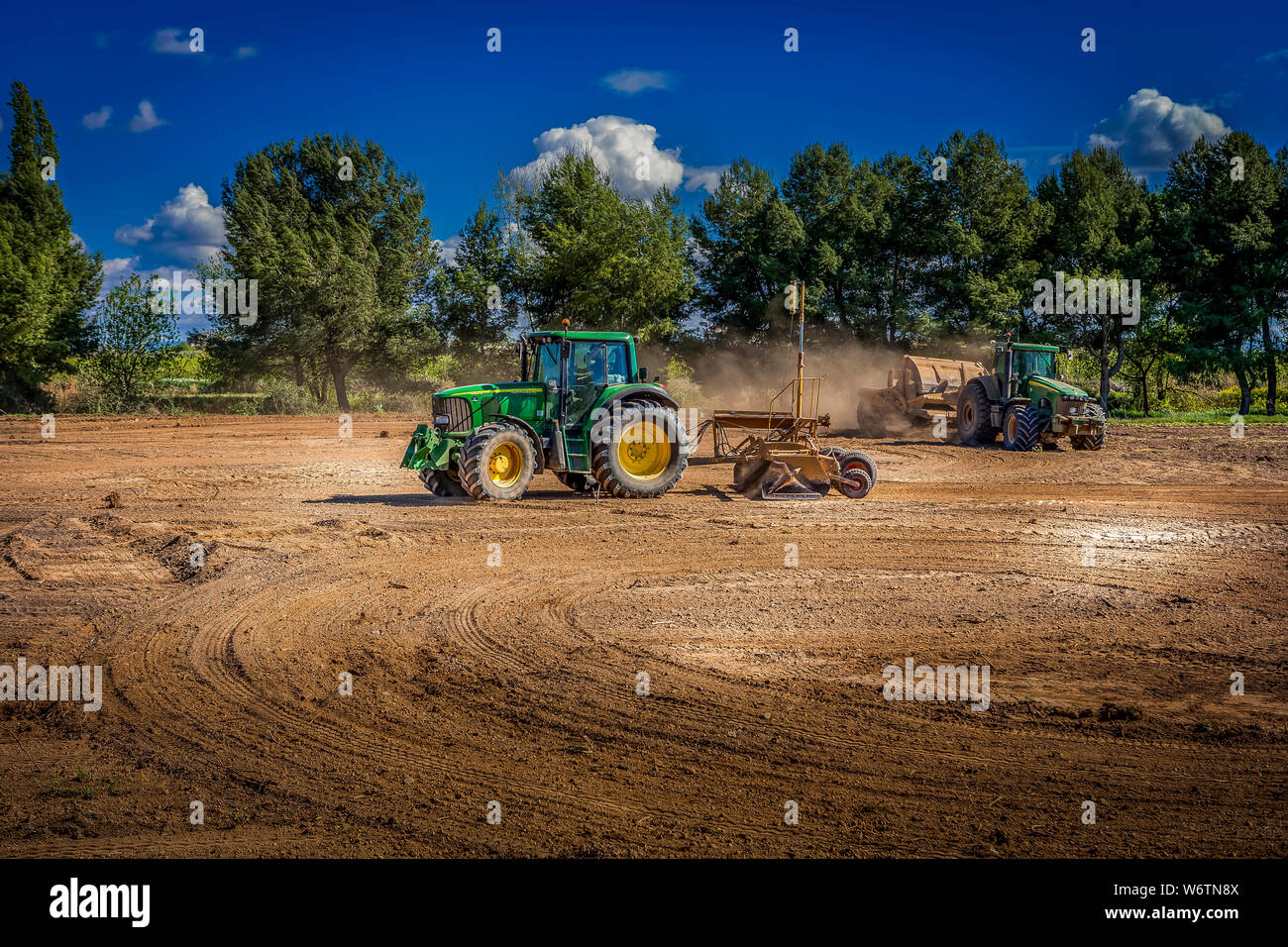 Tractors leveling in the field Stock Photo - Alamy