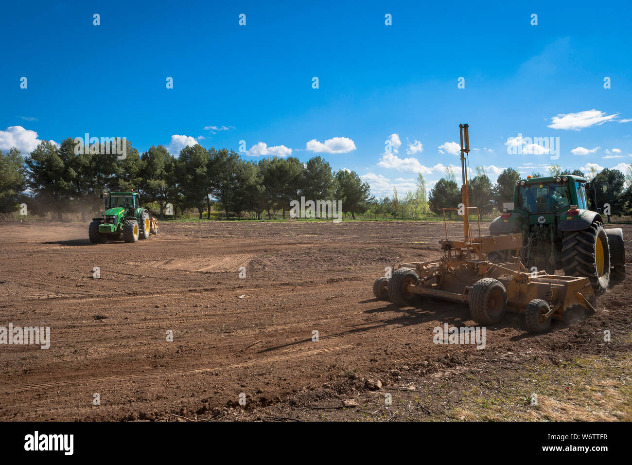 Tractors leveling in the field Stock Photo - Alamy