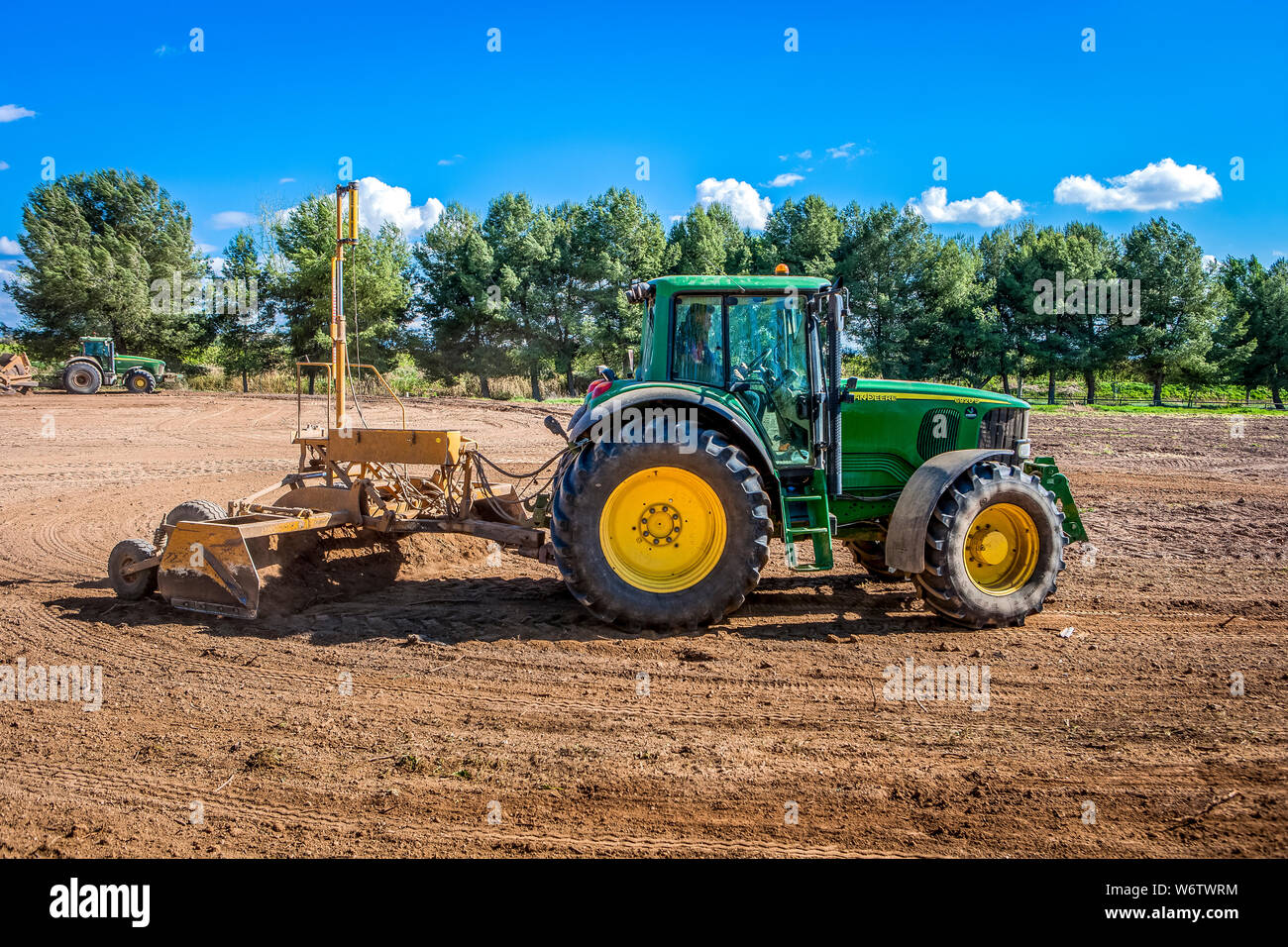 Tractors leveling in the field Stock Photo - Alamy